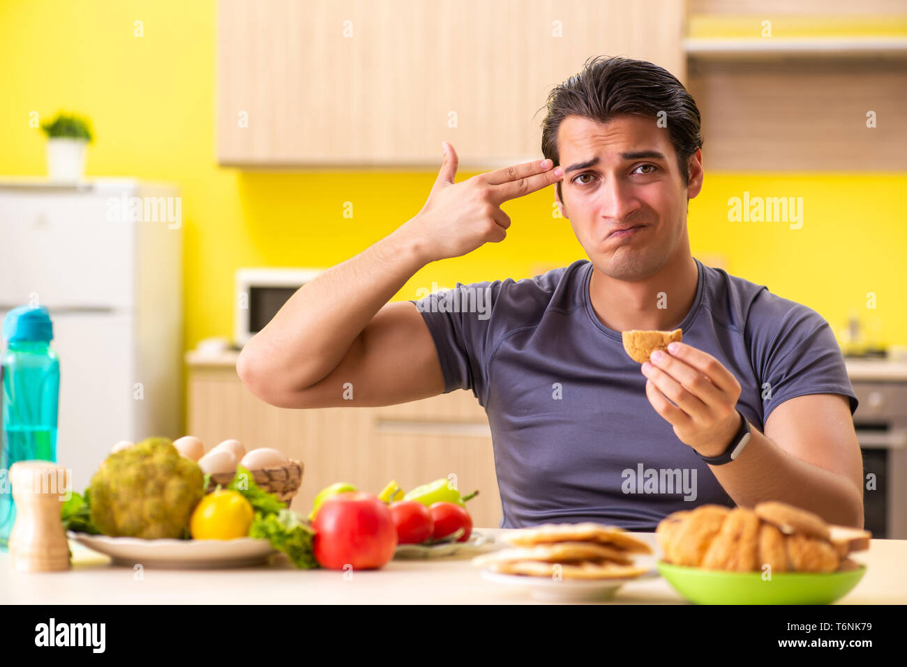 Man having hard choice between healthy and unhealthy food Stock Photo ...