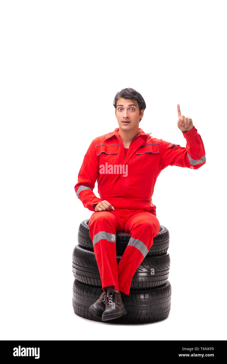 Young garage worker with tyre isolated on white Stock Photo - Alamy