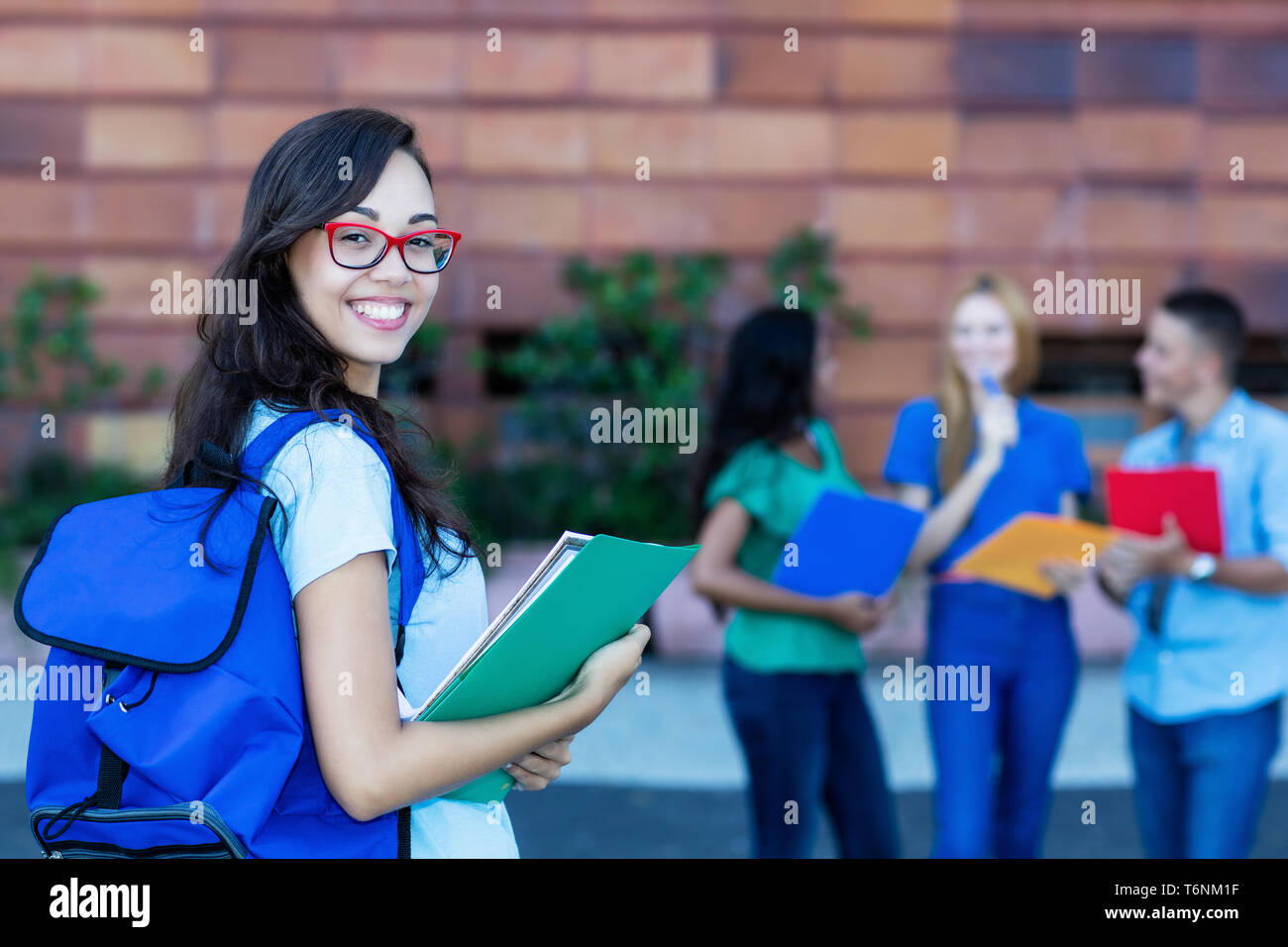 Happy nerdy french female student with group of students outdoor in the ...