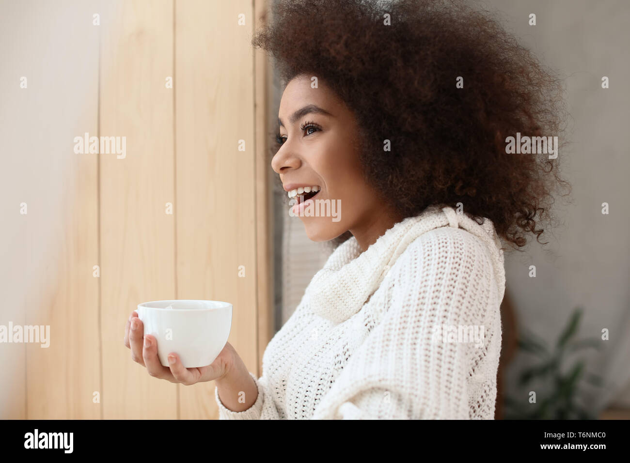 Beautiful African-American woman drinking tea indoors Stock Photo - Alamy
