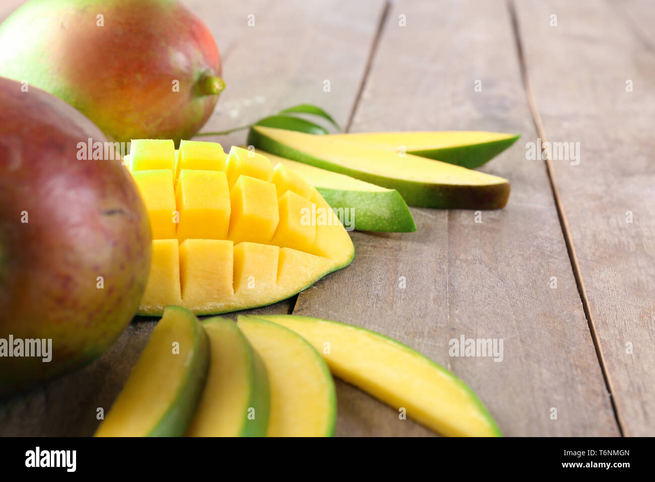 Whole and sliced mangoes on wooden background Stock Photo - Alamy