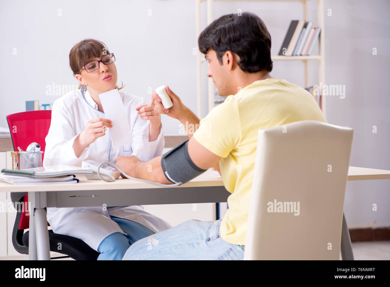 The young doctor checking patients blood pressure Stock Photo - Alamy