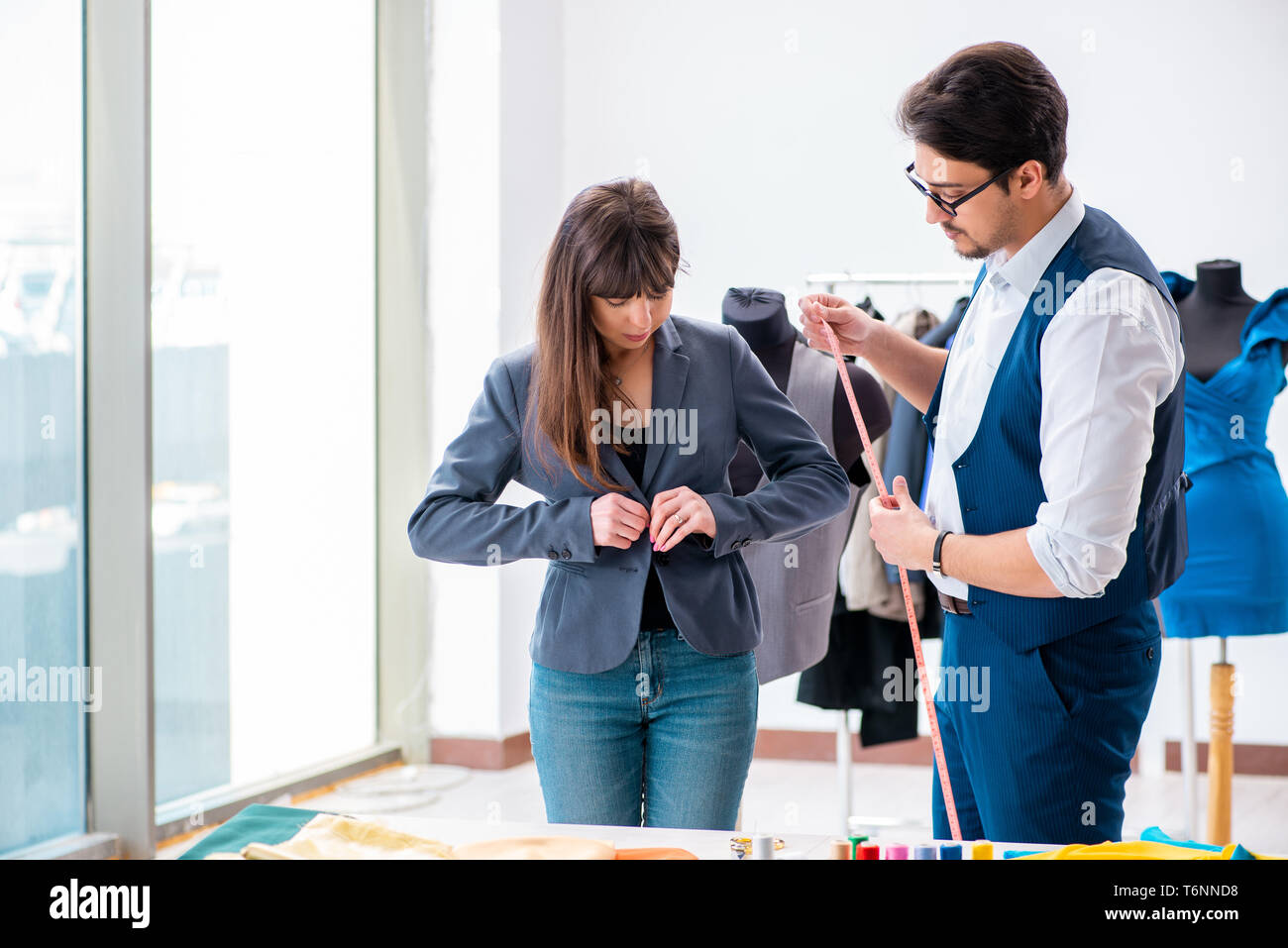 The professional tailor taking measurements for formal suit Stock Photo ...