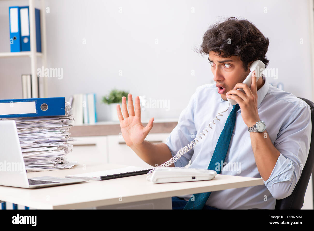 The overloaded busy employee with too much work and paperwork Stock ...