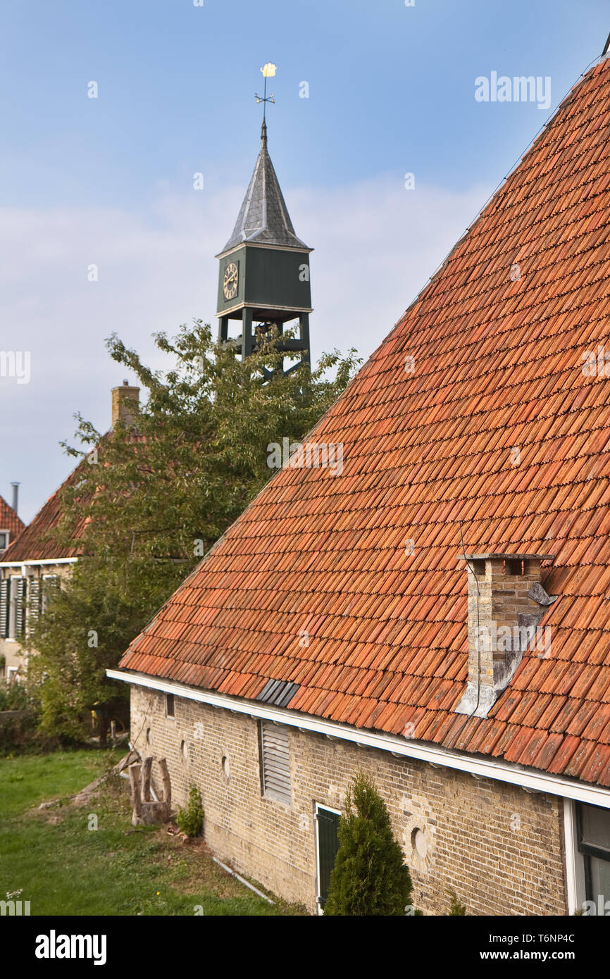 Old dutch historic farmhouse with churchtower behind it Stock Photo - Alamy
