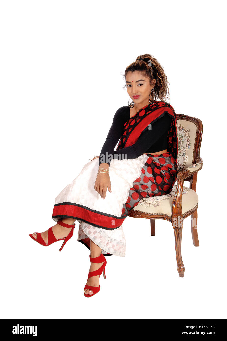 Smiling beautiful East Indian woman sitting in armchair Stock Photo - Alamy