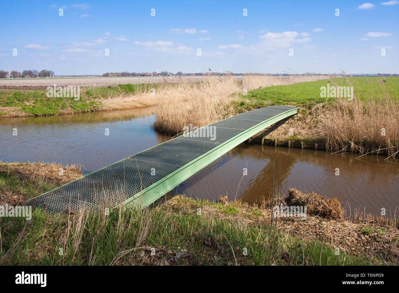 farmland with pedestrian bridge crossing a wide ditch Stock Photo - Alamy