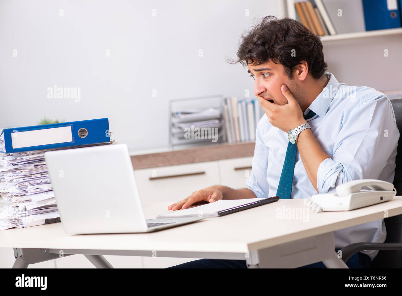 Overloaded busy employee with too much work and paperwork Stock Photo ...