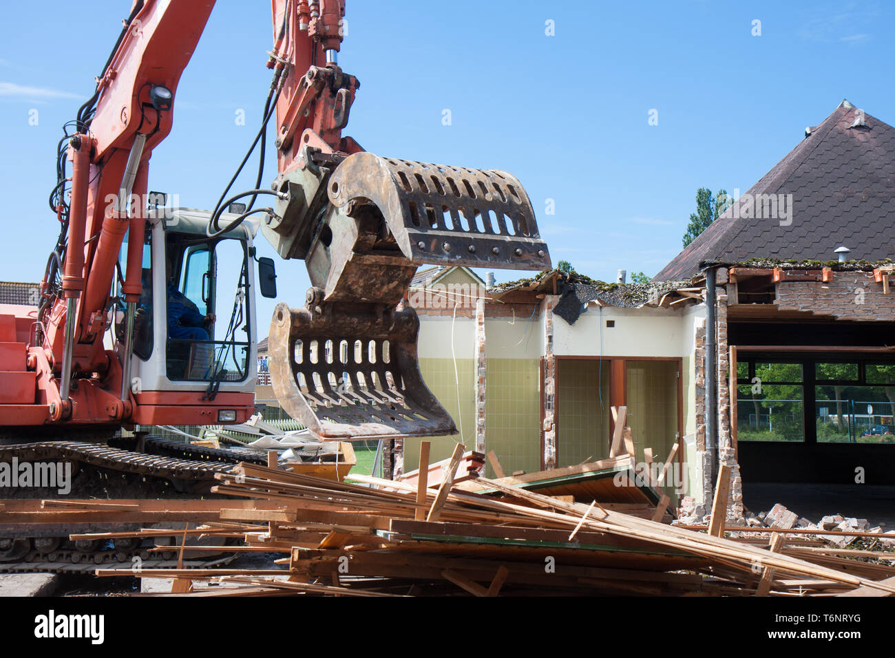 Demolition of a building with a excavator Stock Photo - Alamy