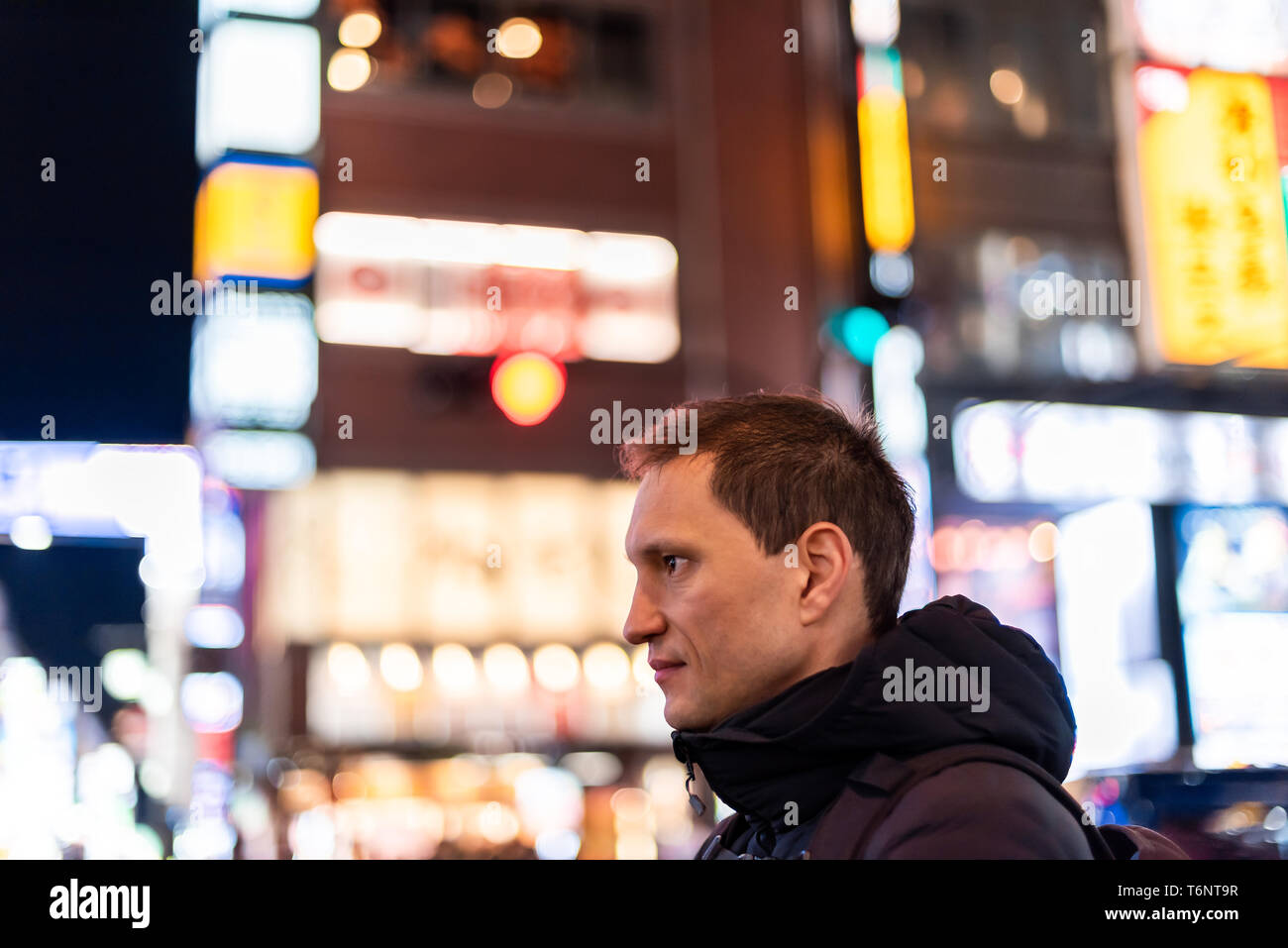 Tokyo, Japan Shinjuku district at night with young man side profile ...