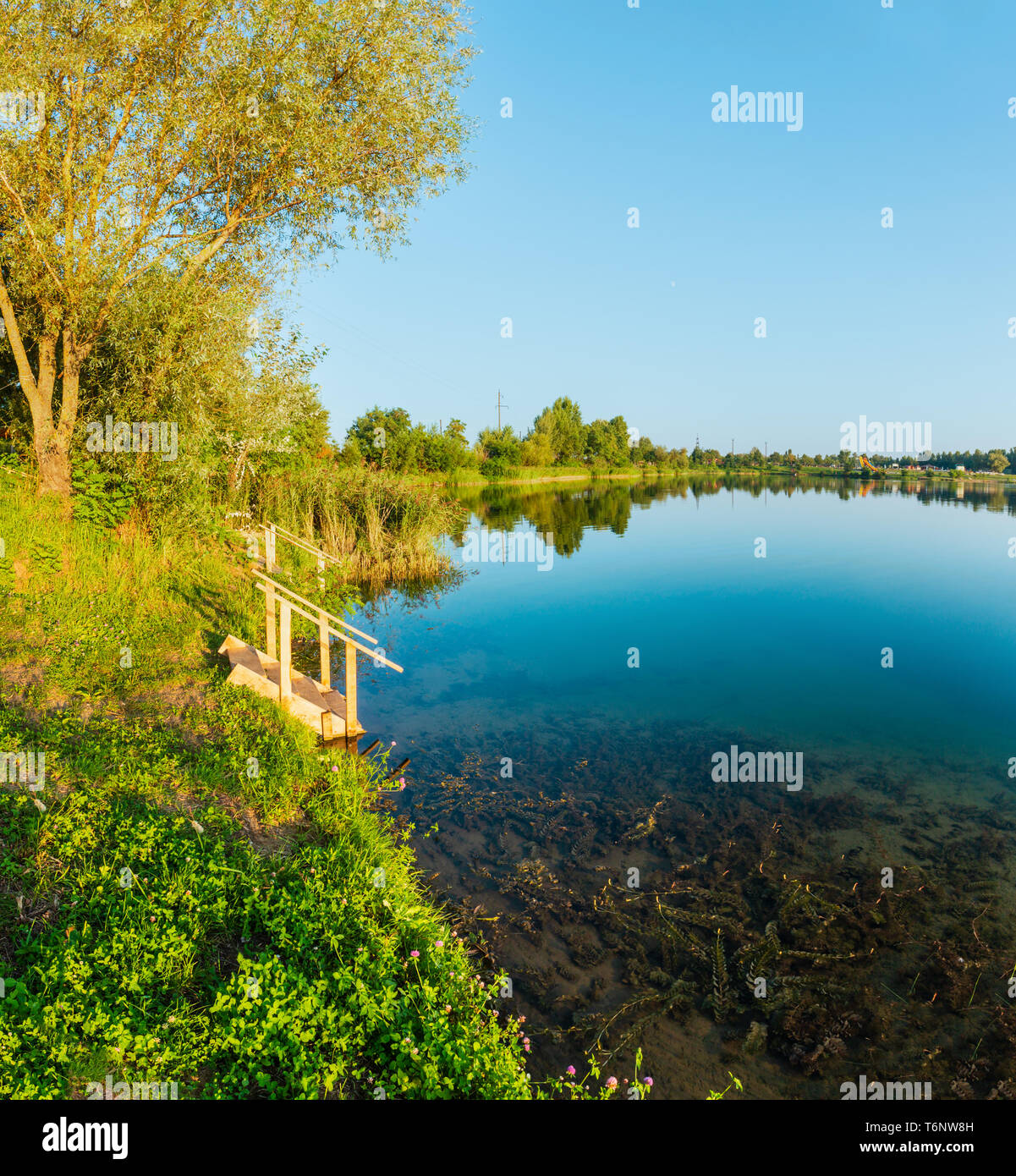 Summer lake calm beach with wood steeps to the water Stock Photo - Alamy