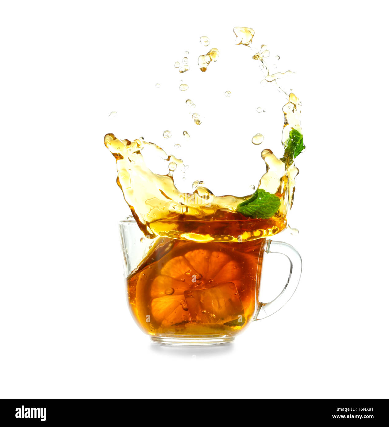 Glass cup and splash of delicious lemon tea with ginger on white ...