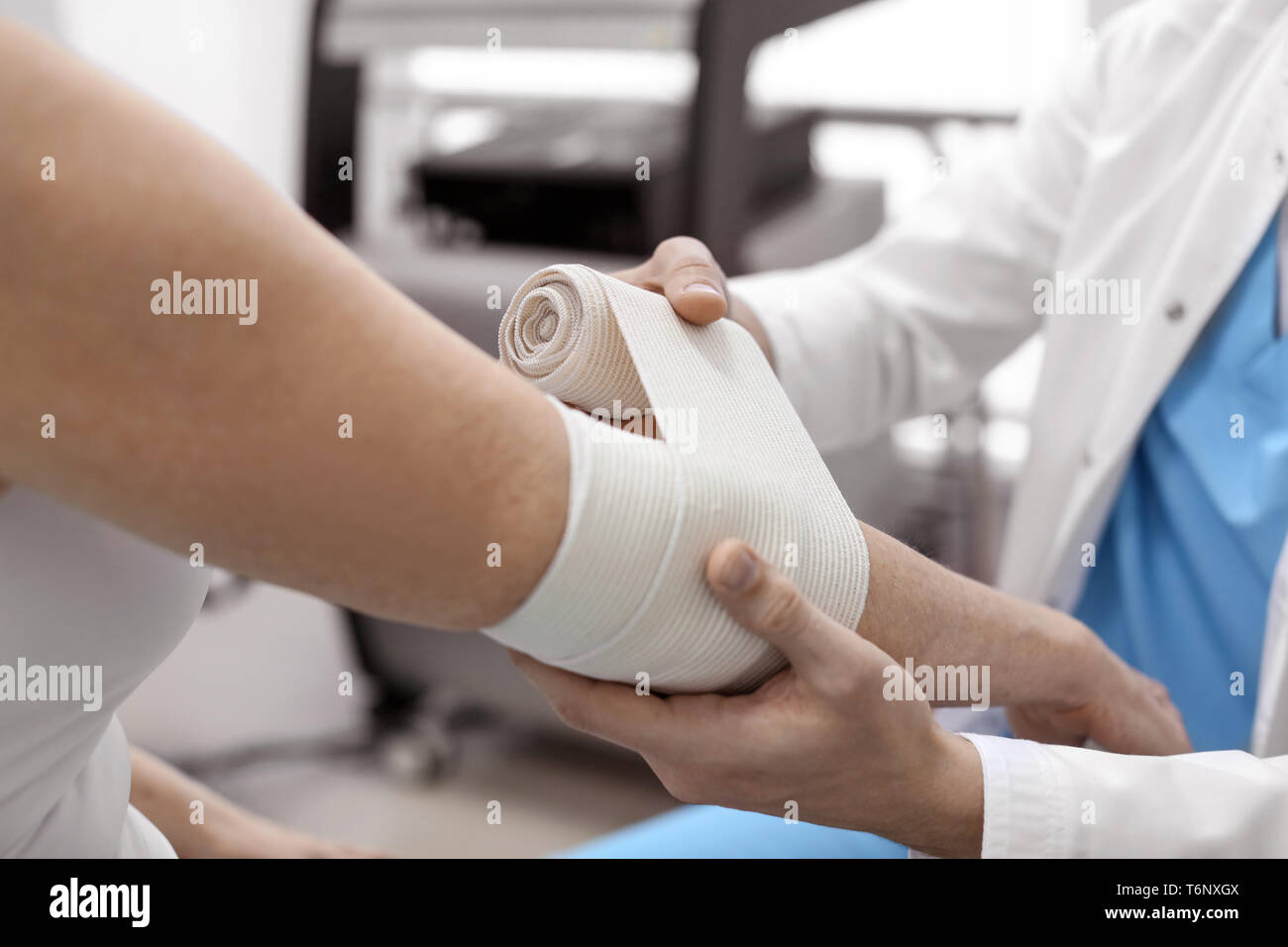 Orthopedist bandaging patient's arm in hospital Stock Photo - Alamy