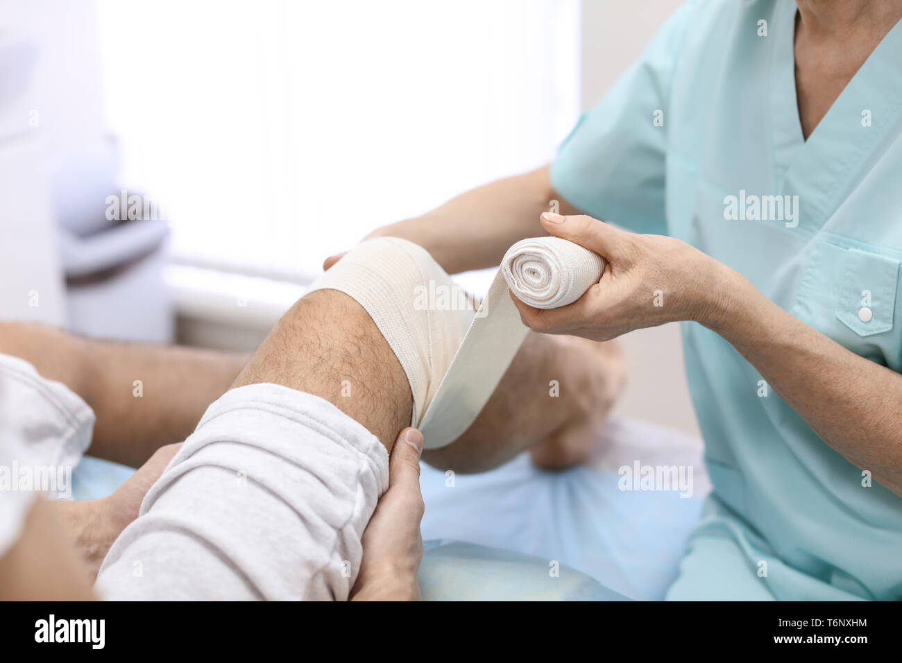 Orthopedist bandaging patient's leg in hospital Stock Photo - Alamy