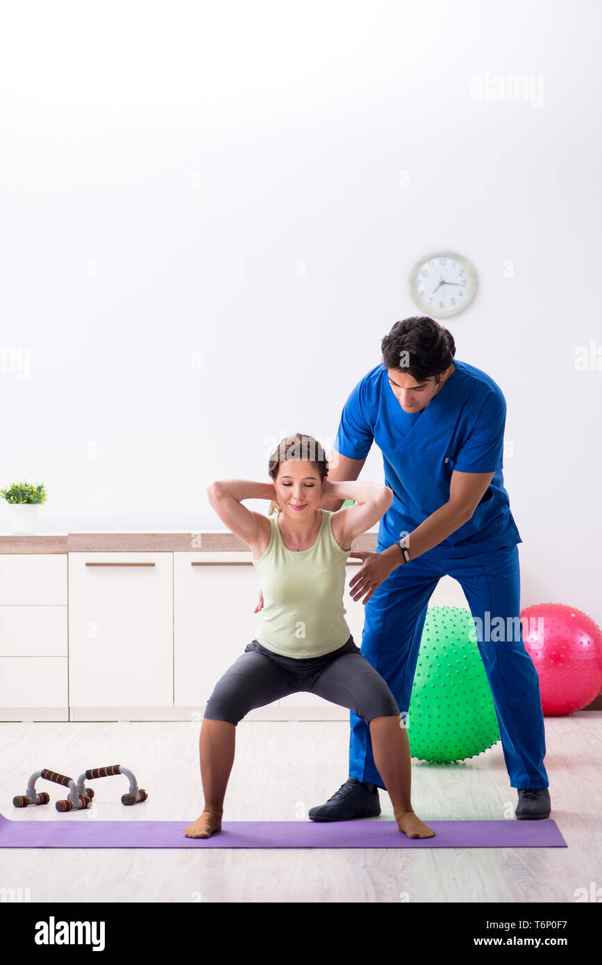 Fitness instructor helping sportsman during exercise Stock Photo - Alamy