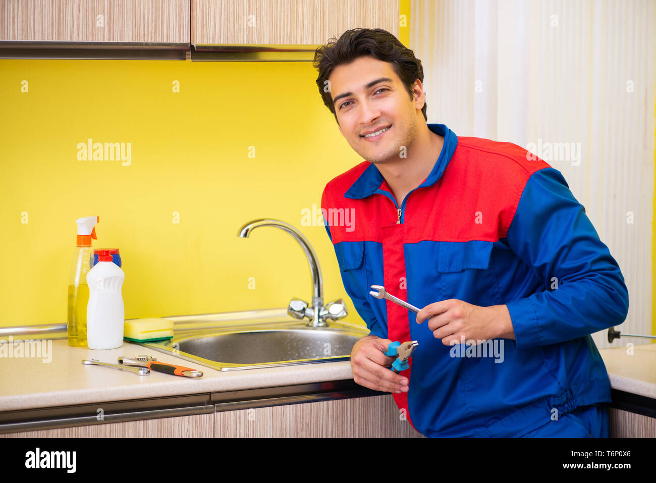 Plumber repairing tap at kitchen Stock Photo - Alamy