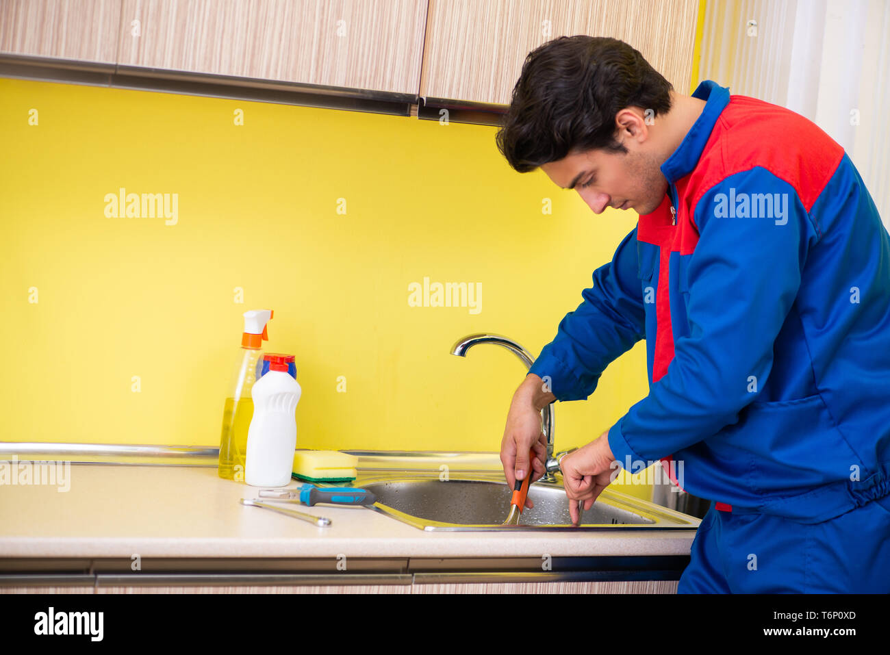 Plumber repairing tap at kitchen Stock Photo - Alamy