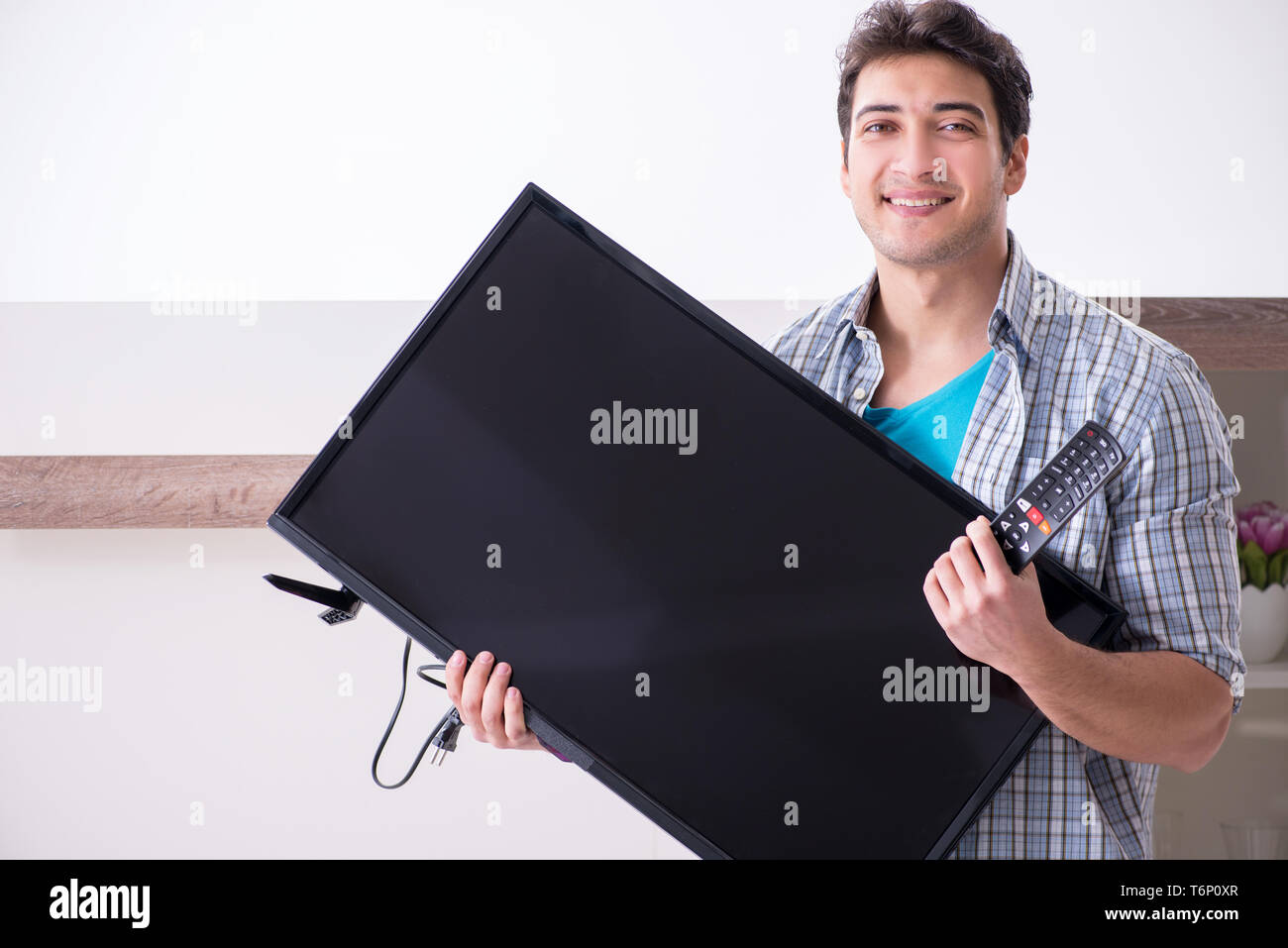 Man trying to fix broken tv Stock Photo - Alamy