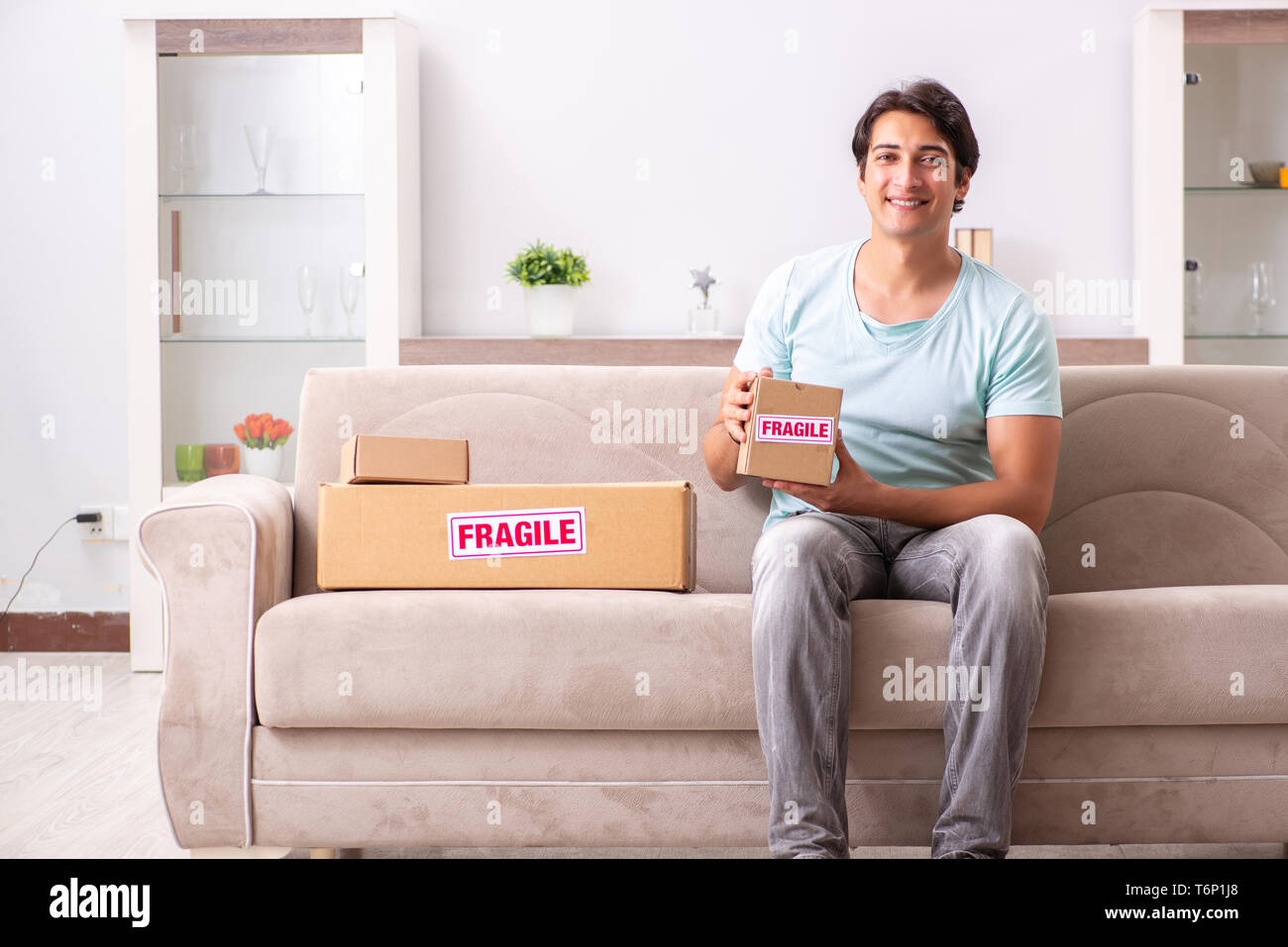 Man opening fragile parcel ordered from internet Stock Photo - Alamy