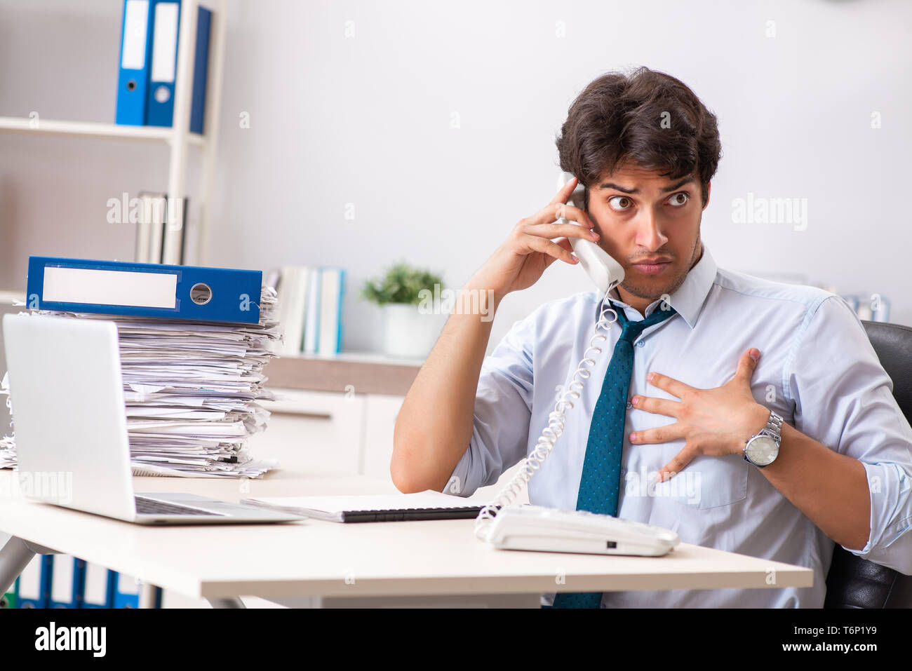 Overloaded busy employee with too much work and paperwork Stock Photo ...