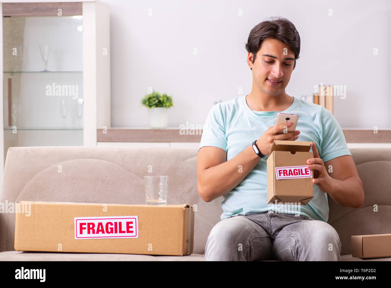 Man opening fragile parcel ordered from internet Stock Photo - Alamy
