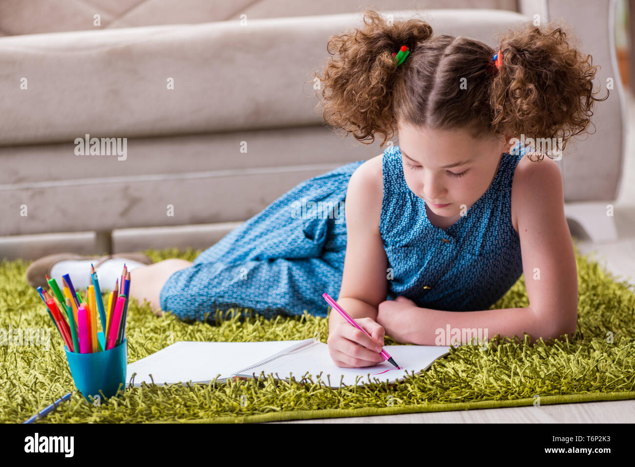Young little girl drawing on paper with pencils Stock Photo - Alamy