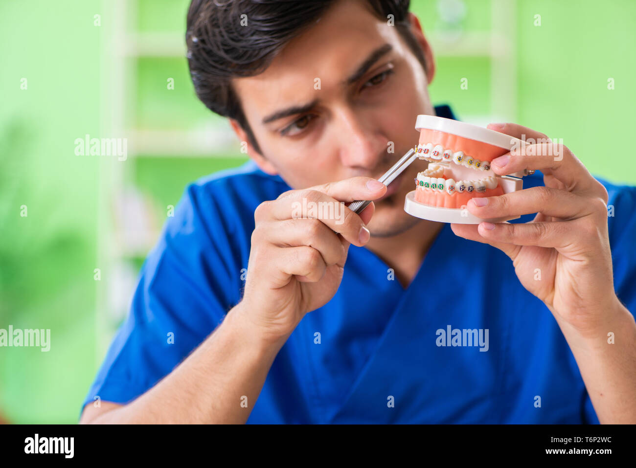 Man dentist working on new teeth implant Stock Photo - Alamy