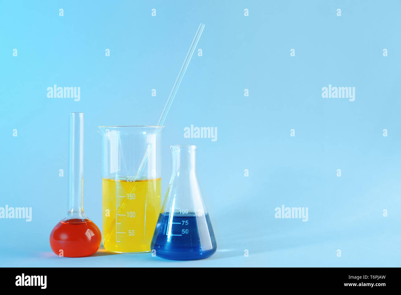 Chemical glassware with colorful samples on color background Stock ...