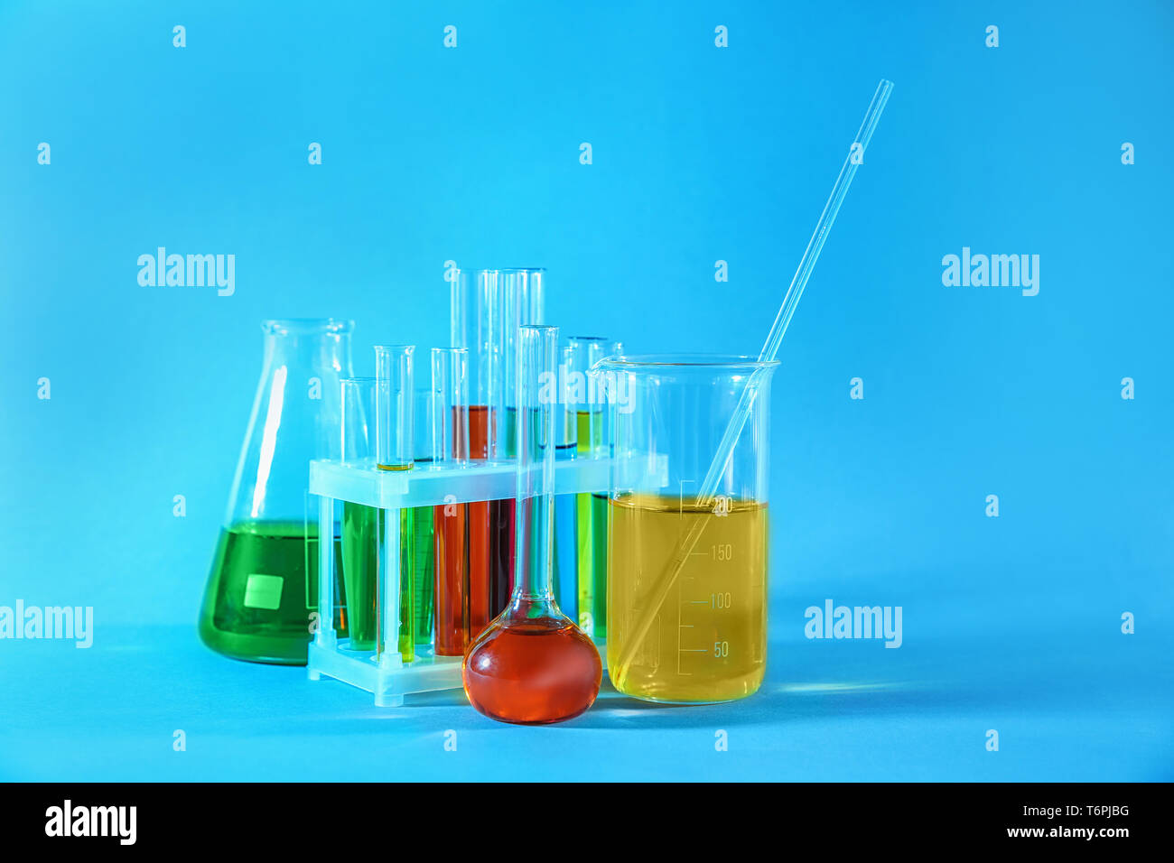 Chemical glassware with colorful samples on color background Stock ...