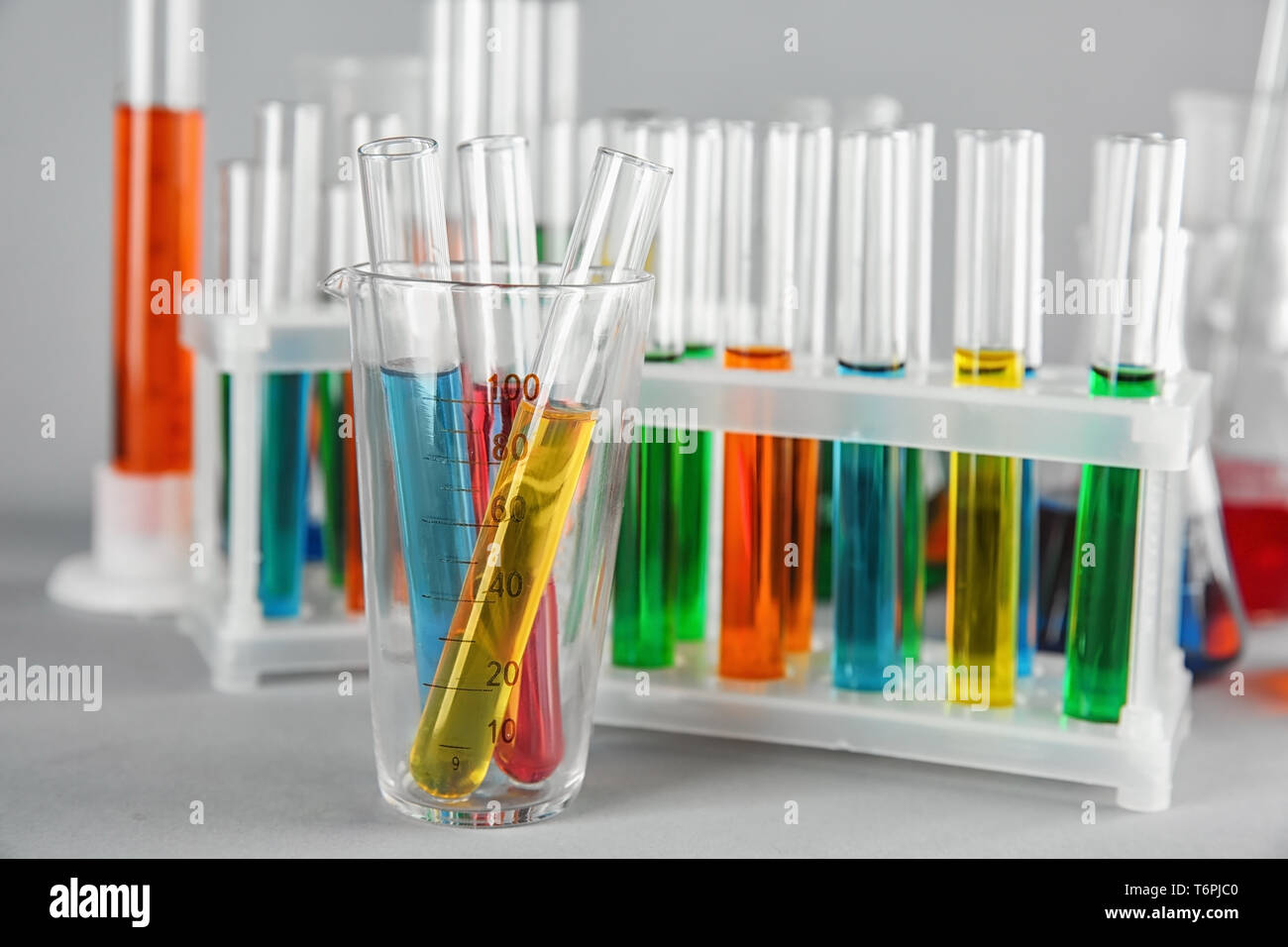 Test tubes with colorful liquids in beaker on table Stock Photo - Alamy