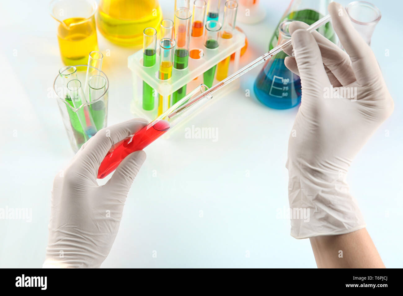 Lab worker taking sample from test tube with red liquid, closeup Stock ...