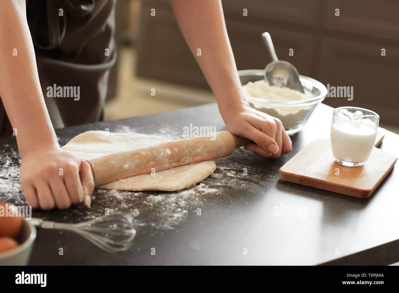 Baker rolling dough on kitchen table Stock Photo - Alamy