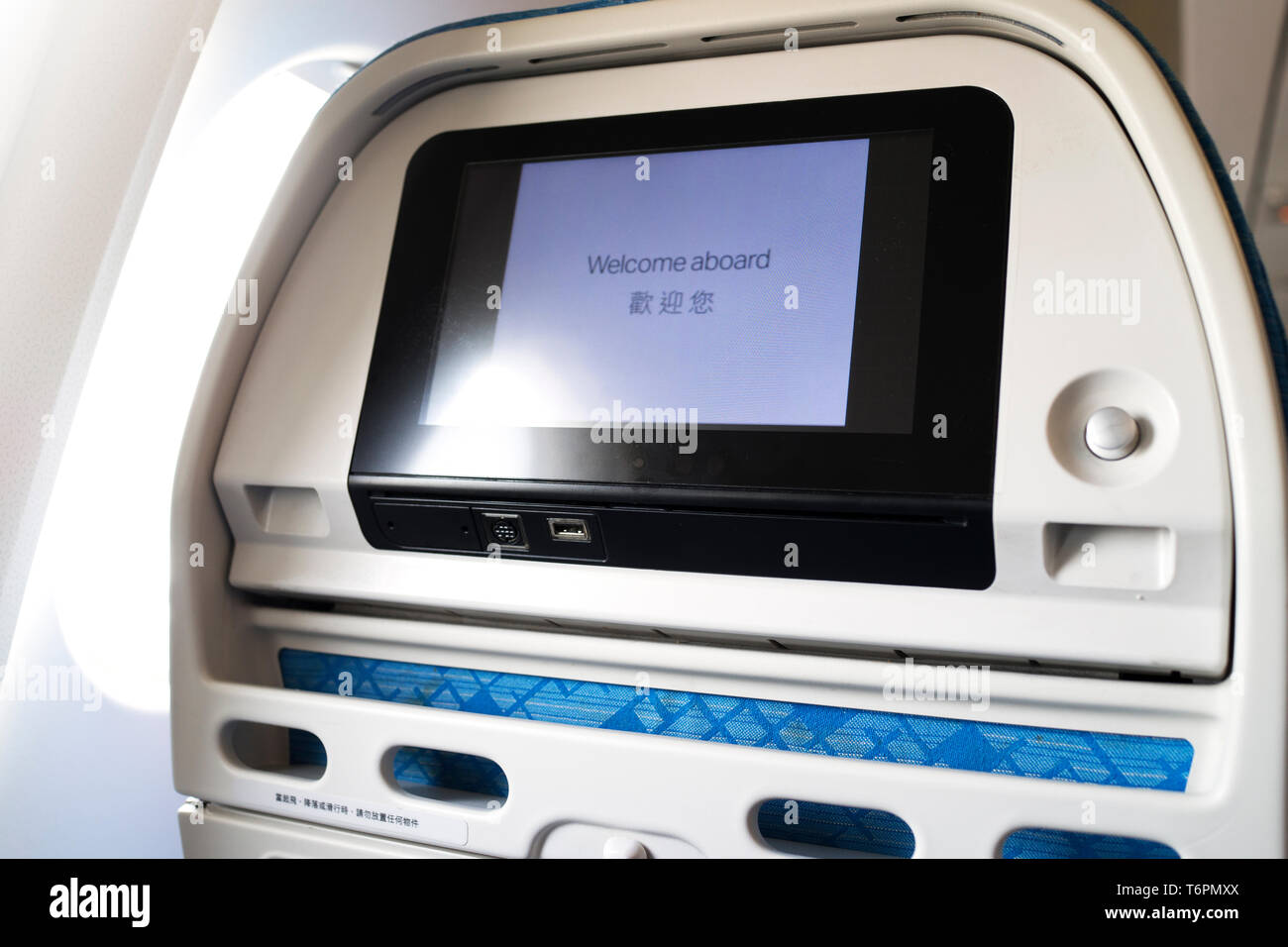 Airplane monitor behind passenger seat with sun light through from the ...
