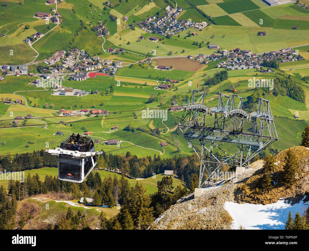 A gondola of the Stanserhorn Cabrio aerial cable car heading downwards ...