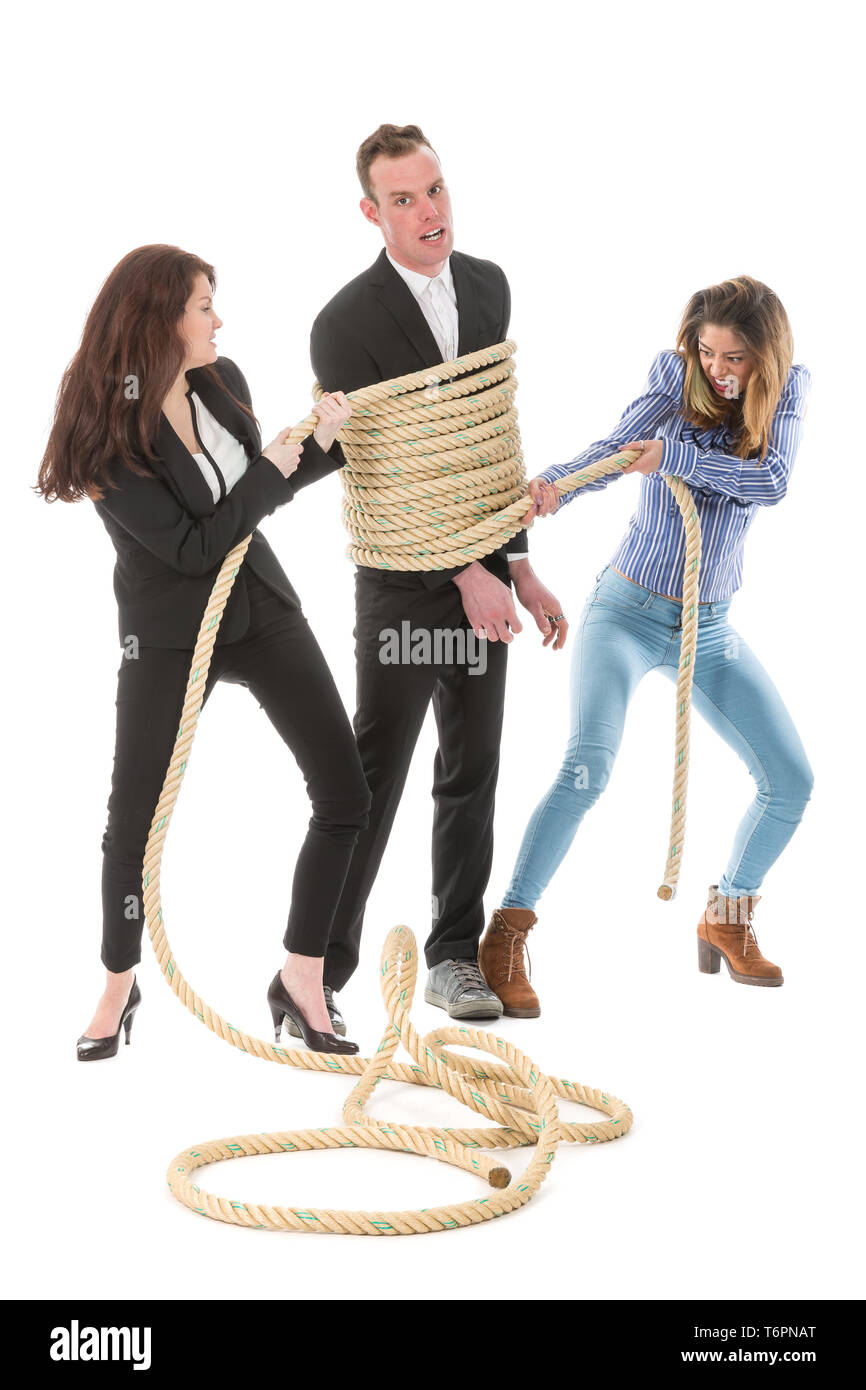 Two angry woman tying a business man with rope Stock Photo - Alamy
