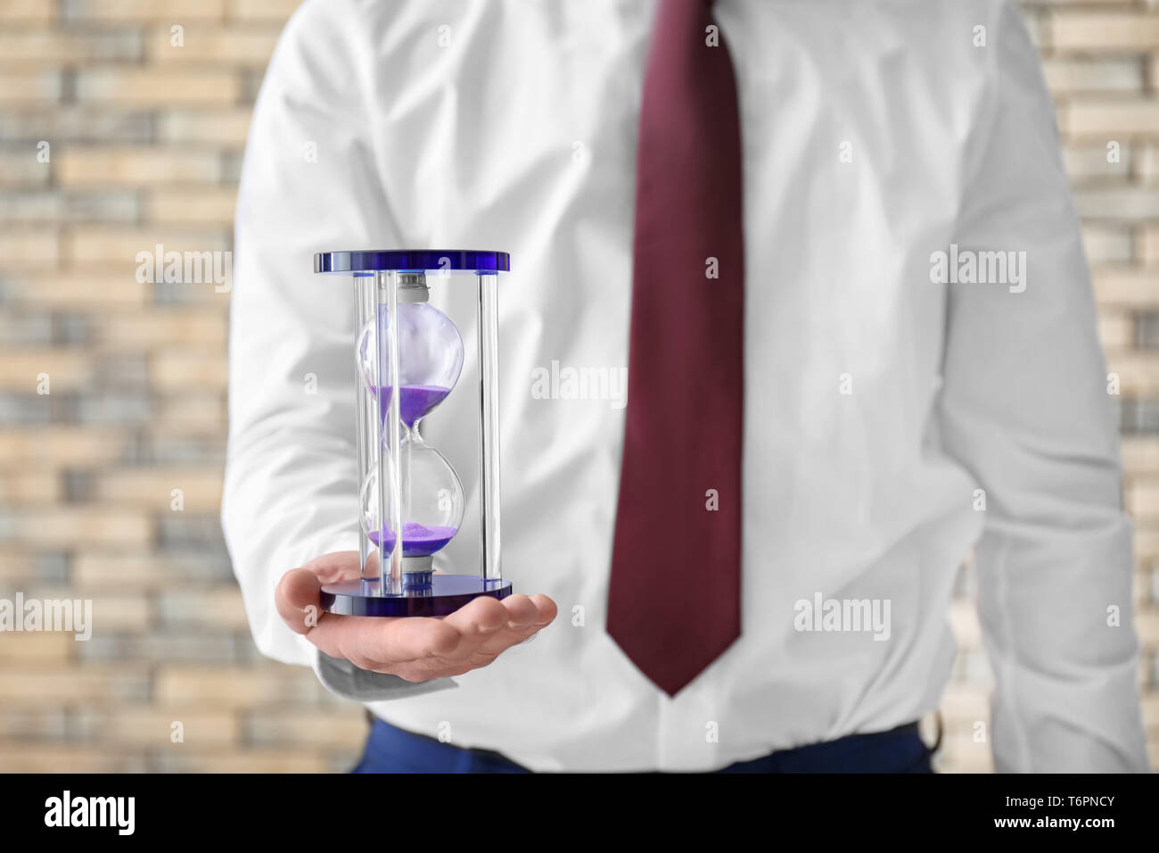 Man holding hourglass on blurred background, closeup. Time management ...