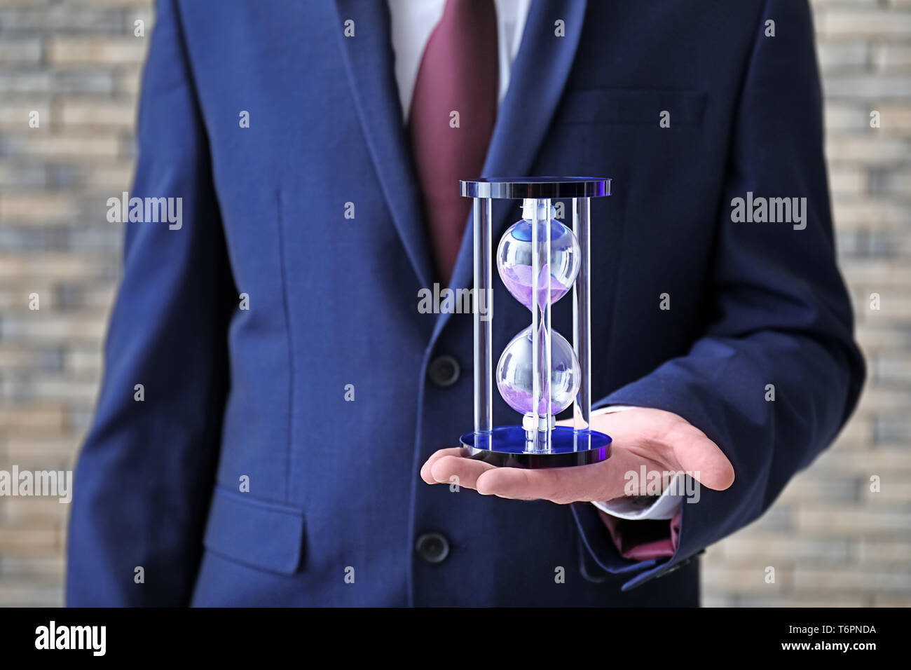 Man holding hourglass on blurred background, closeup. Time management ...