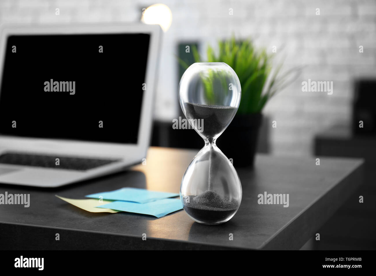 Hourglass on table in office. Time management concept Stock Photo - Alamy