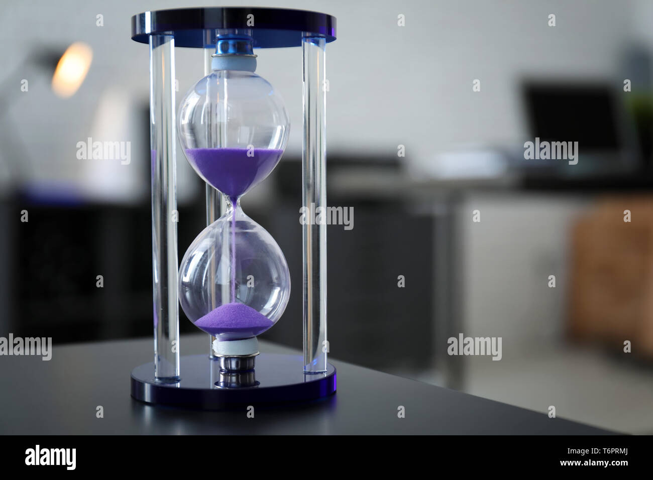 Hourglass on table in office. Time management concept Stock Photo - Alamy