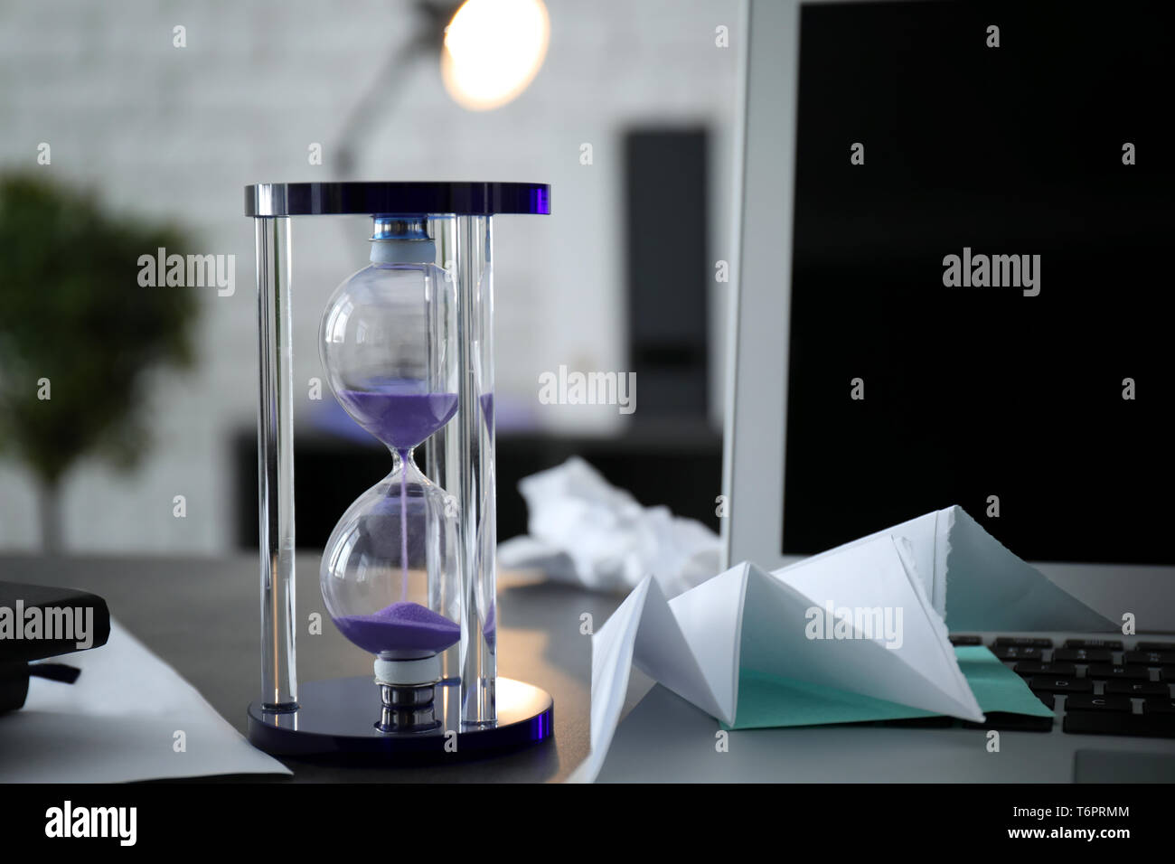 Hourglass on table in office. Time management concept Stock Photo - Alamy