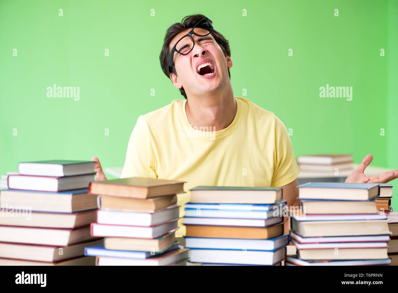 Student with too many books to read before exam Stock Photo - Alamy