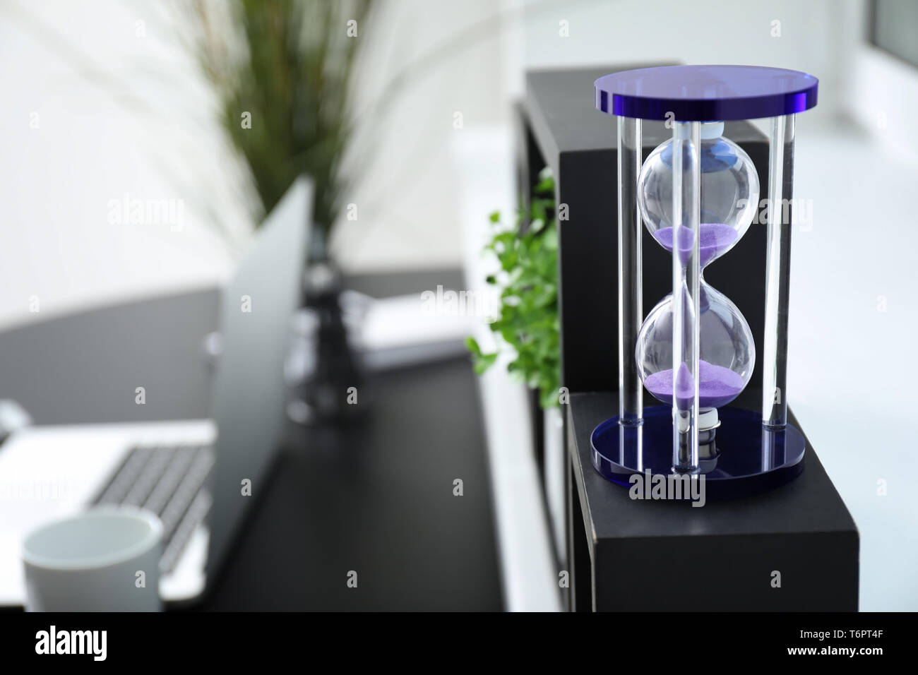 Hourglass on table in office. Time management concept Stock Photo - Alamy