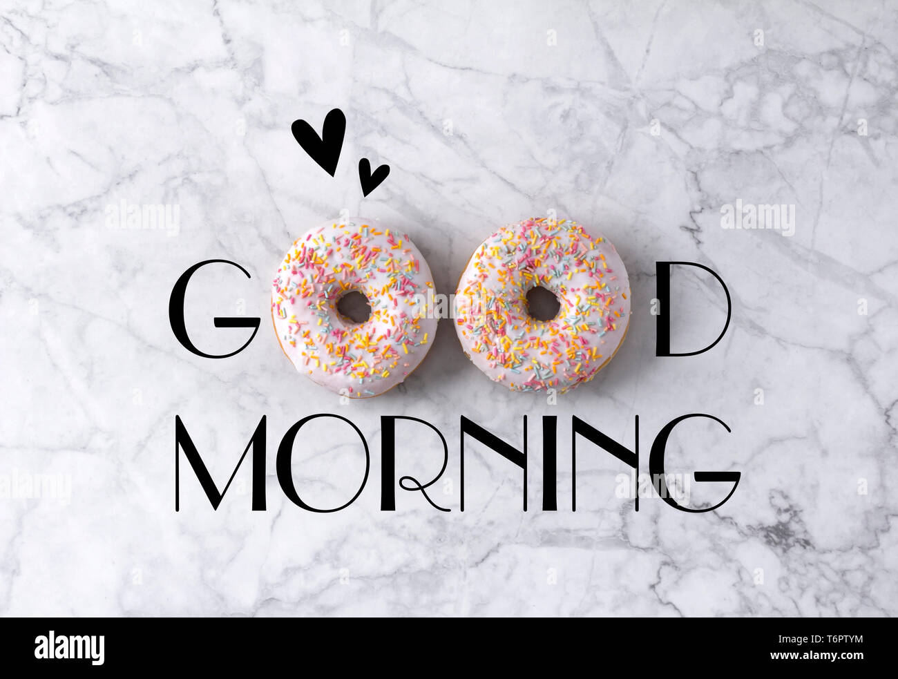 Two donuts and hearts. Good morning greeting written on marble gray ...