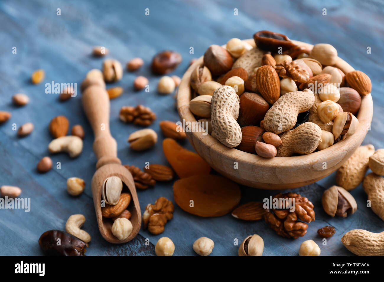 Various tasty nuts with bowl and scoop on color background Stock Photo ...