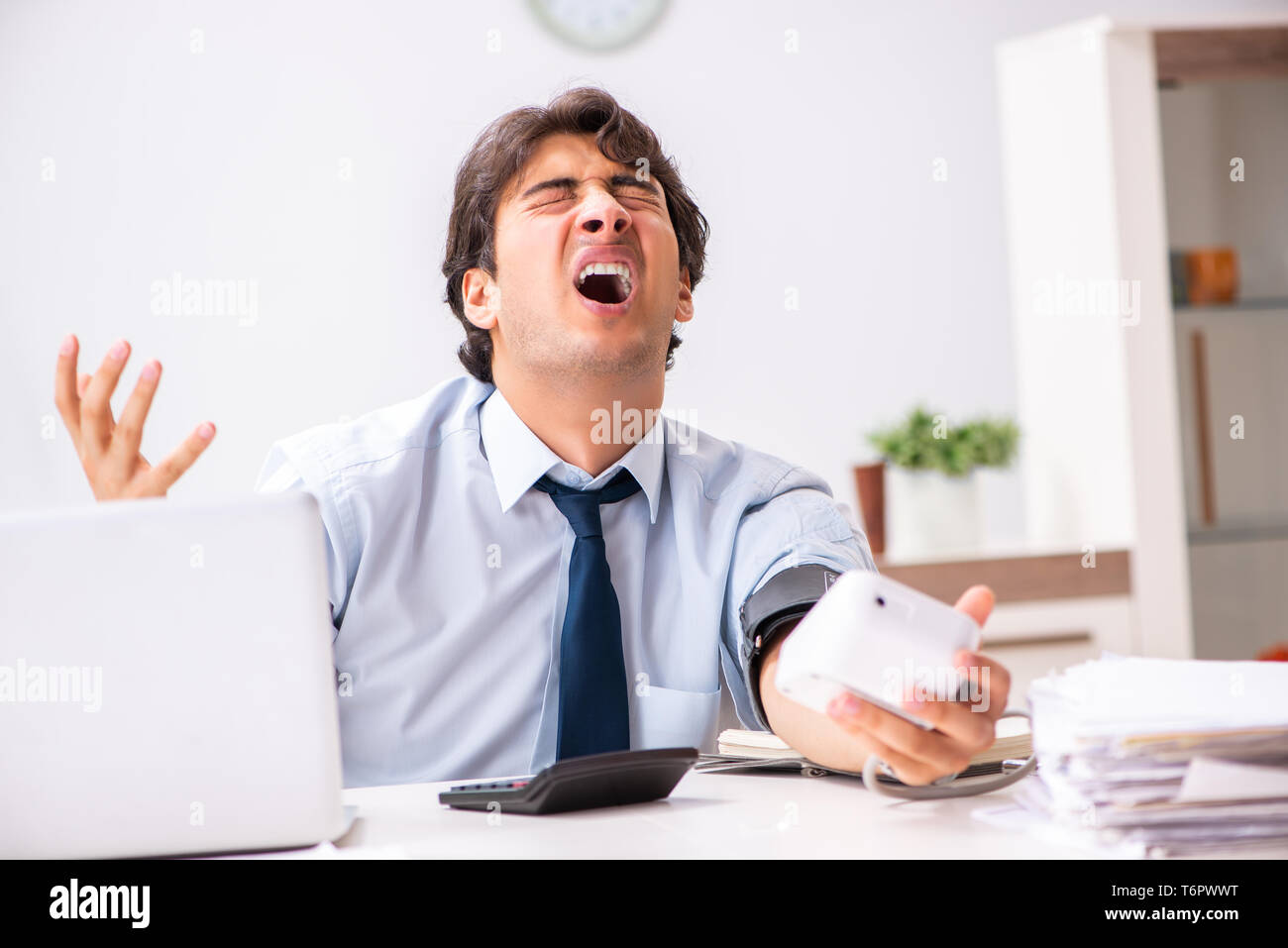 Man under stress measuring his blood pressure Stock Photo - Alamy