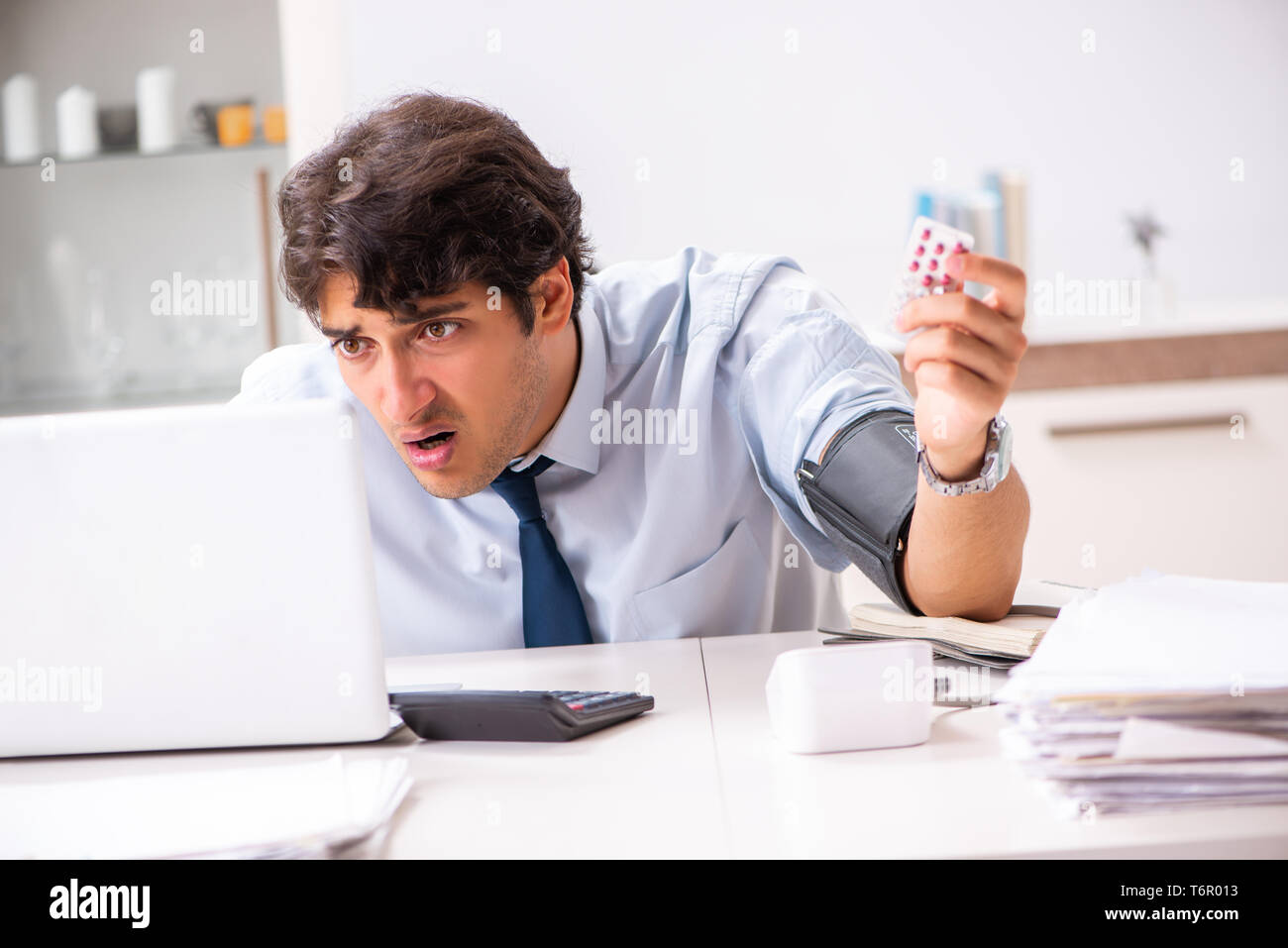 Man under stress measuring his blood pressure Stock Photo - Alamy