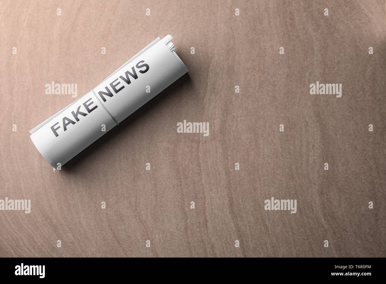 Roll of papers with phrase FAKE NEWS on table Stock Photo - Alamy