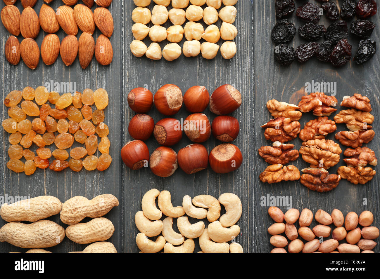 Different kinds of nuts and dried fruits on wooden background, top view ...