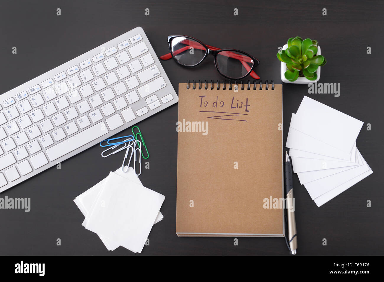 Composition with empty to-do list and computer keyboard on dark ...