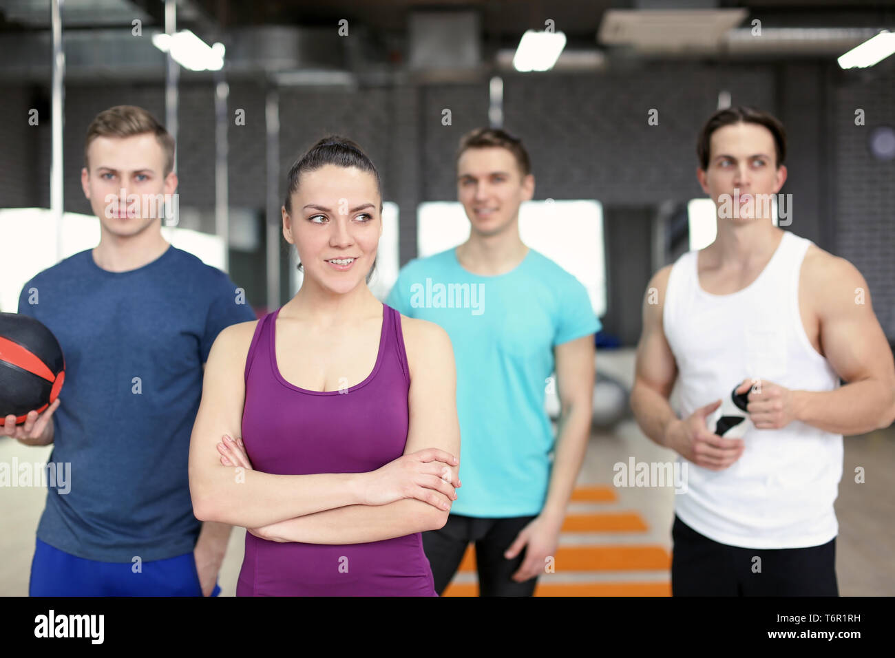 Sporty girl with group of athletes in gym Stock Photo - Alamy